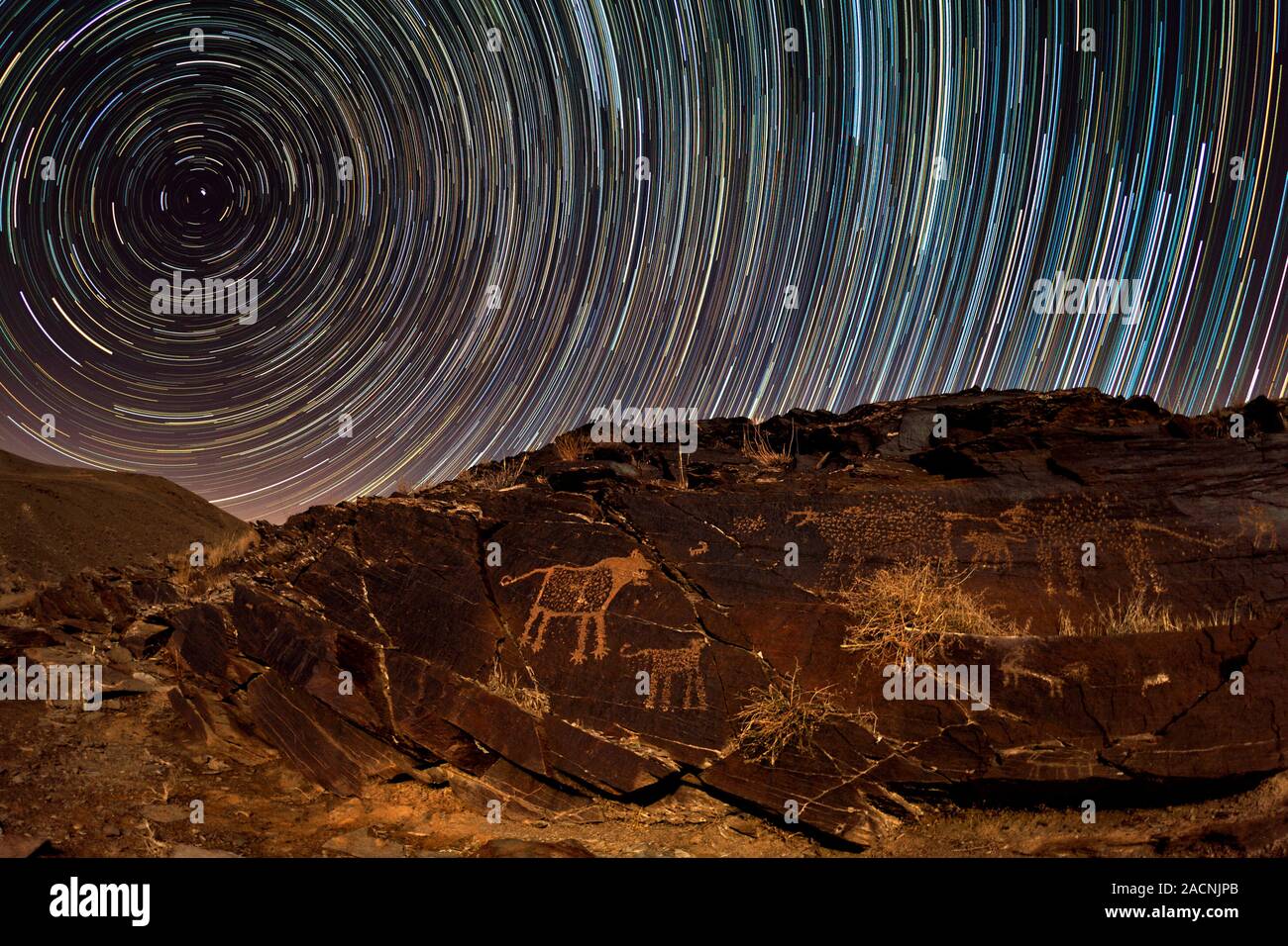 Star trails over rock carvings. Time-exposure image of stars passing ...