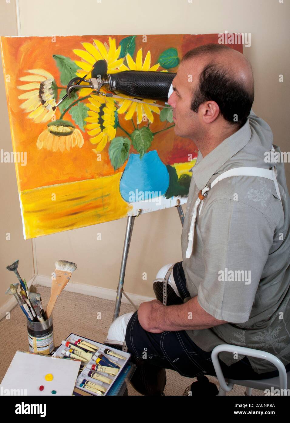 Amputee painting. A 52 year old multiple amputee using a prosthetic ...