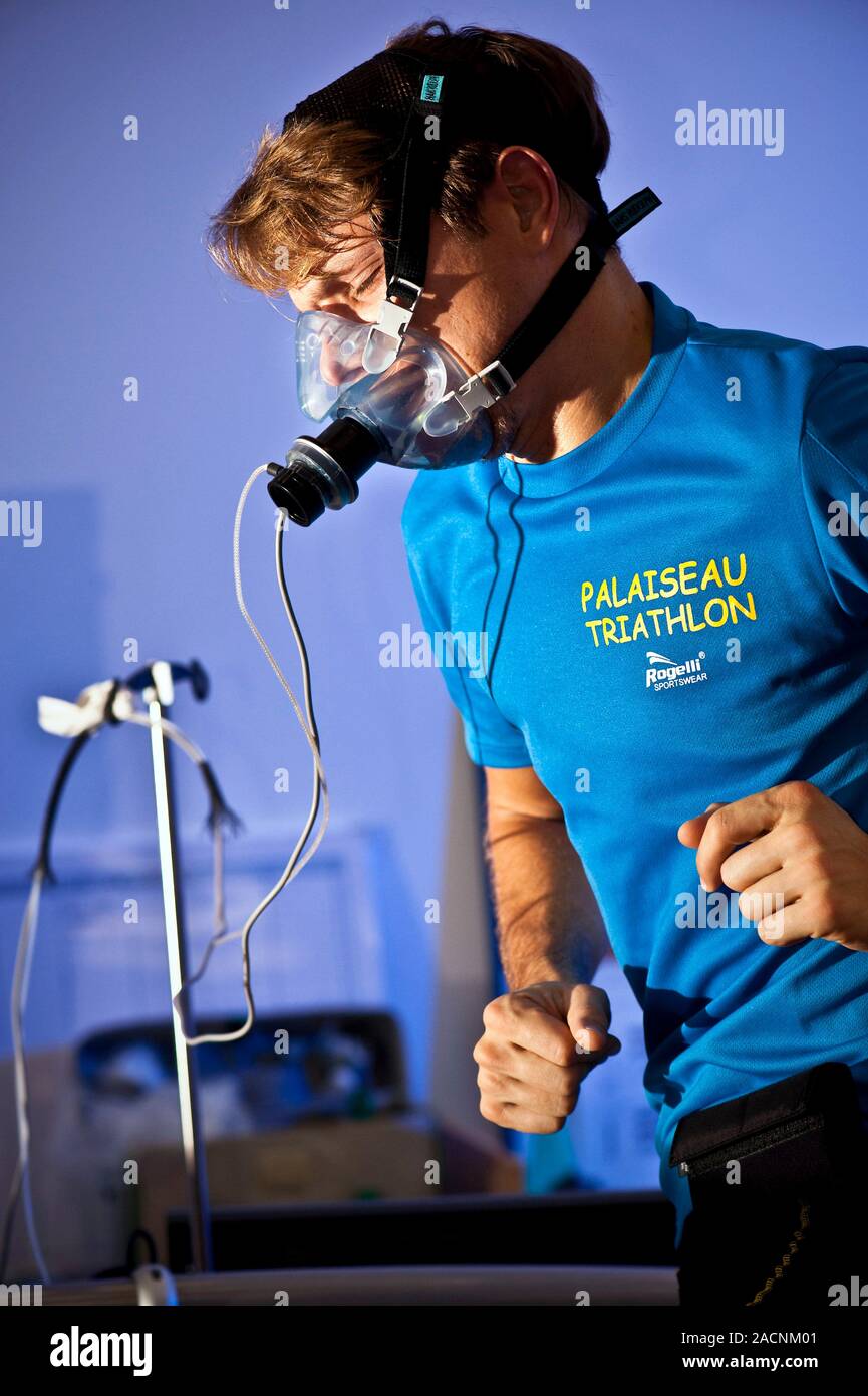 Fitness testing. Athlete running on a treadmill while his oxygen ...