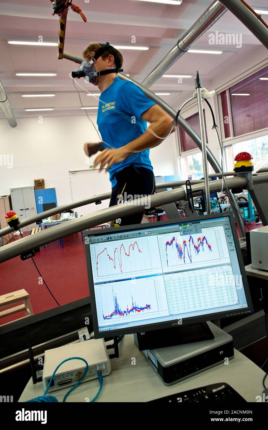 Fitness testing. Athlete running on a treadmill while his oxygen ...