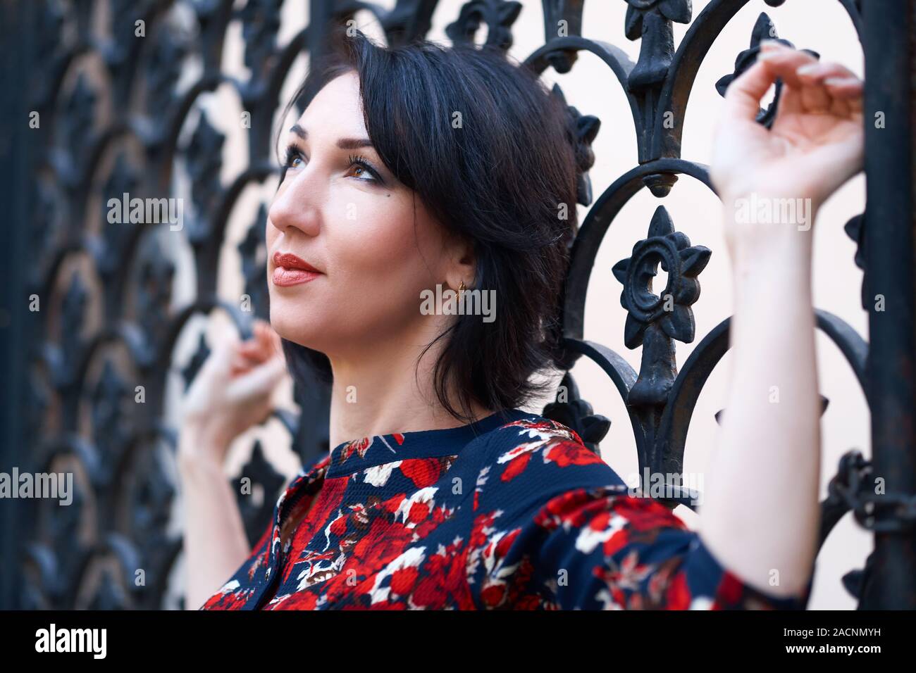 Beautiful elegant woman posing near black wrought iron gates Stock ...