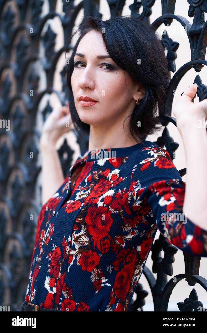 Beautiful elegant woman posing near black wrought iron gates Stock ...