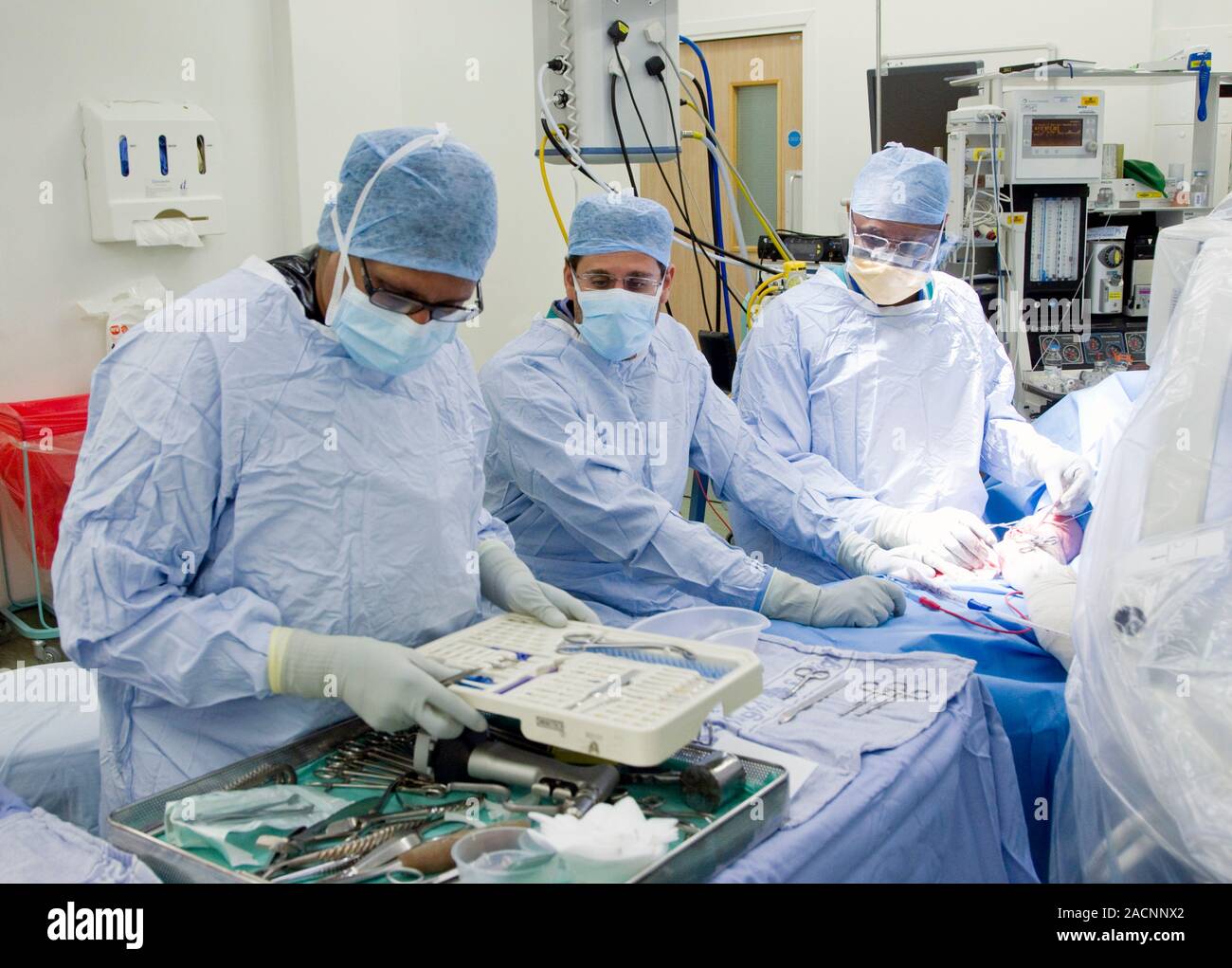 Arm fracture surgery. Surgeons operating on a patient during surgery to ...