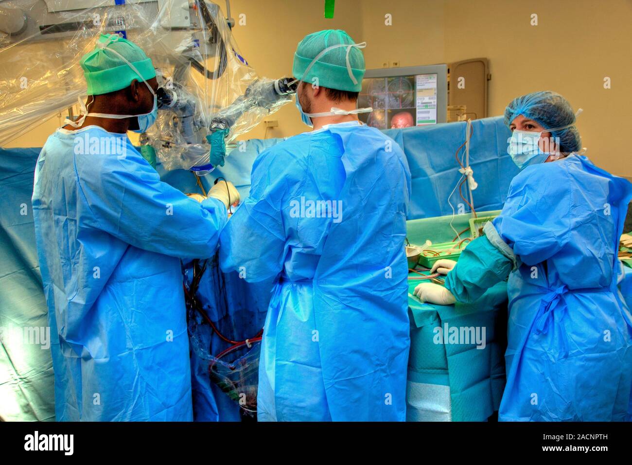 Brain surgery. Surgeons removing a tumour from a patient's brain ...