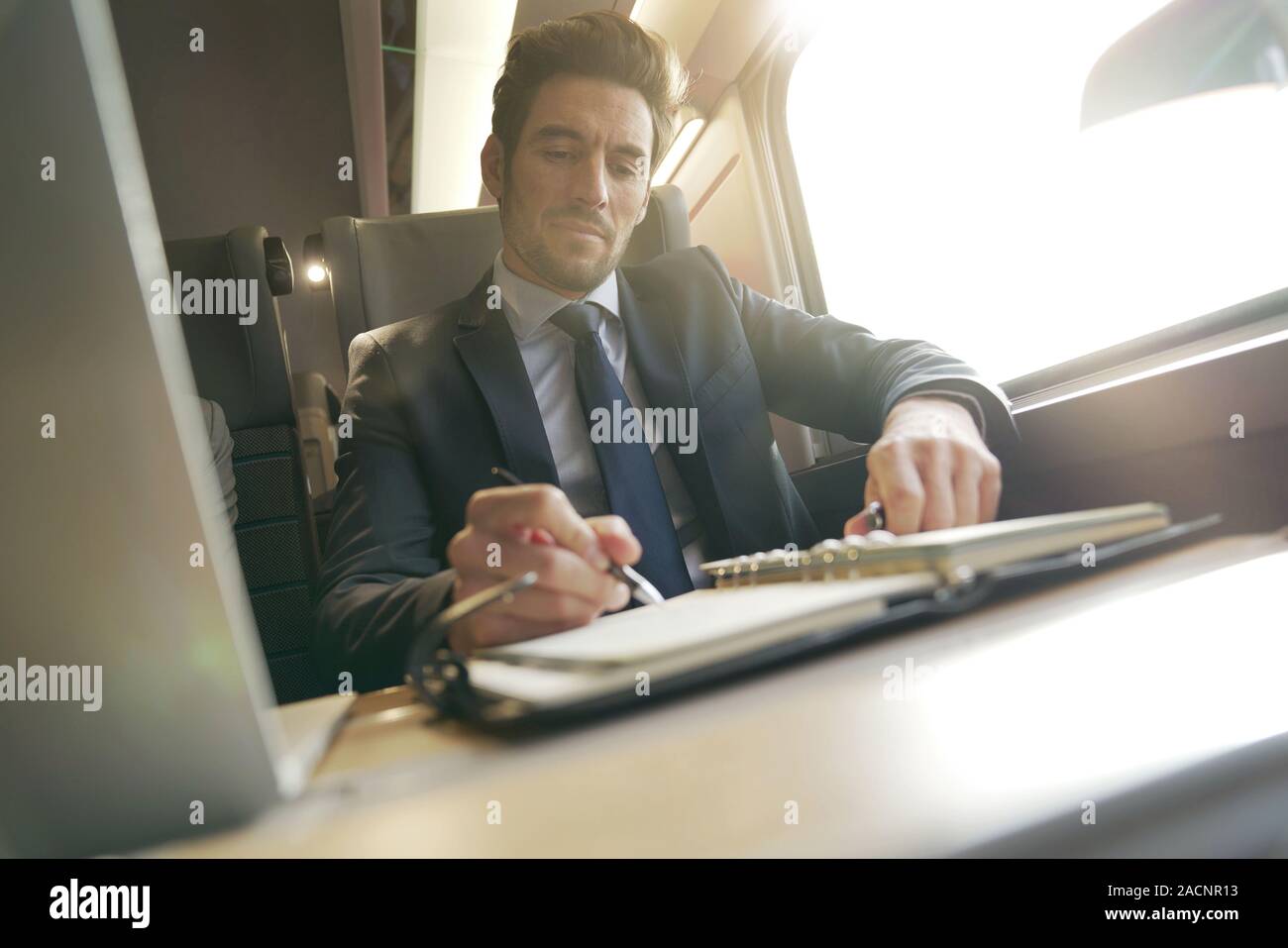 businessman working on a train in business class Stock Photo - Alamy