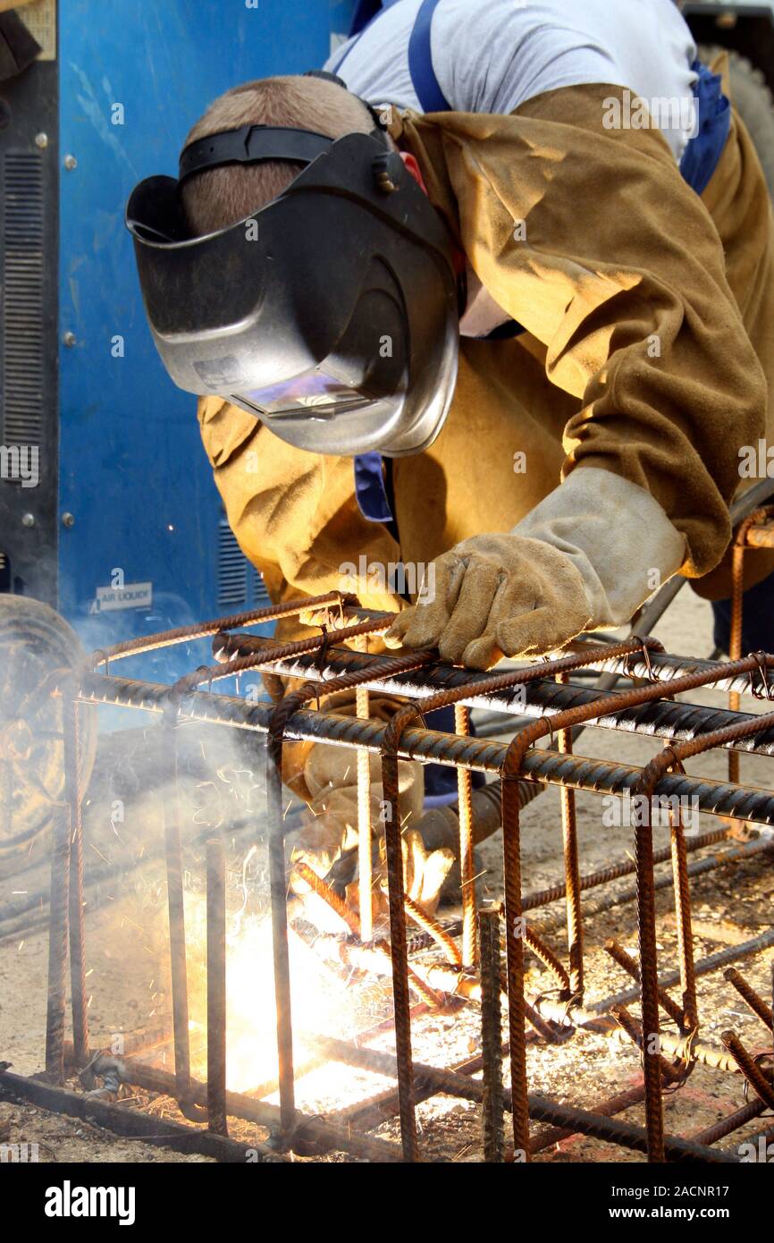 Railway line construction. Working welding a steel frame during ...