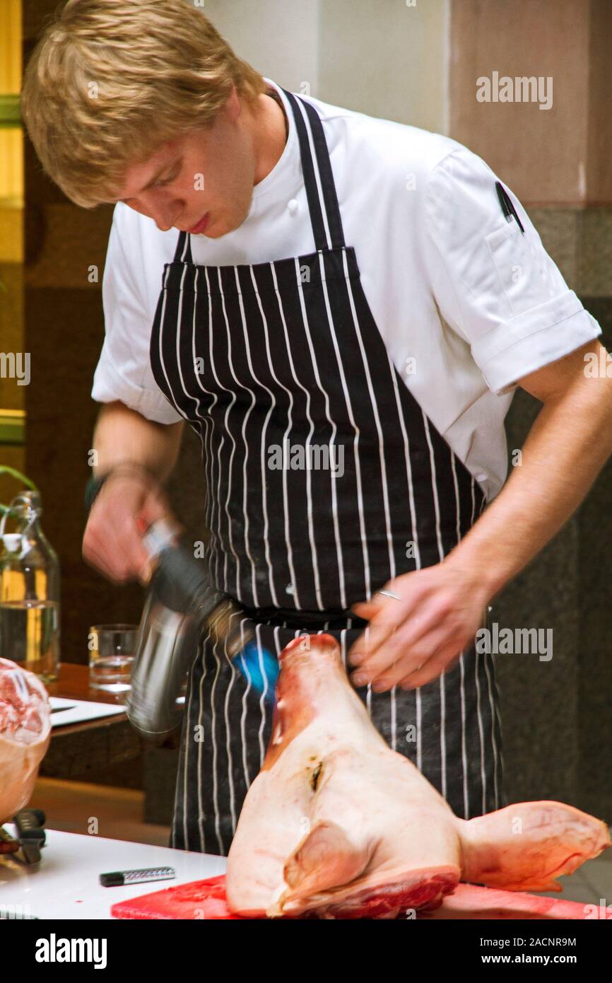 Pork butchery. Pig's carcass being butchered for use at a restaurant ...