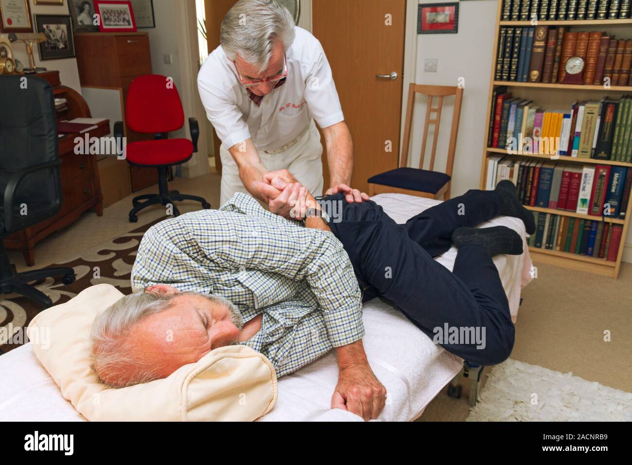 Physiotherapy. Physiotherapist carrying out manipulation to realign a ...