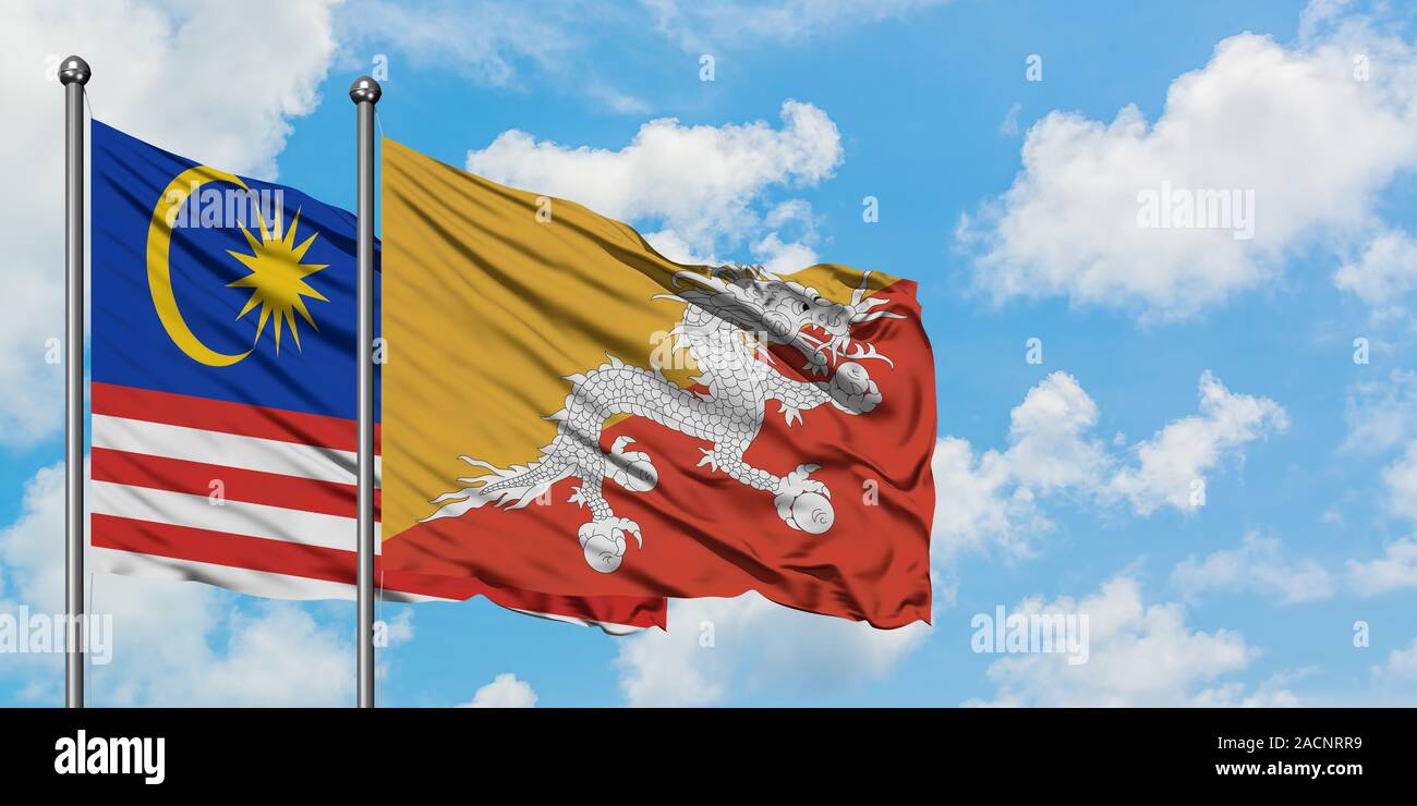 Malaysia and Bhutan flag waving in the wind against white cloudy blue ...