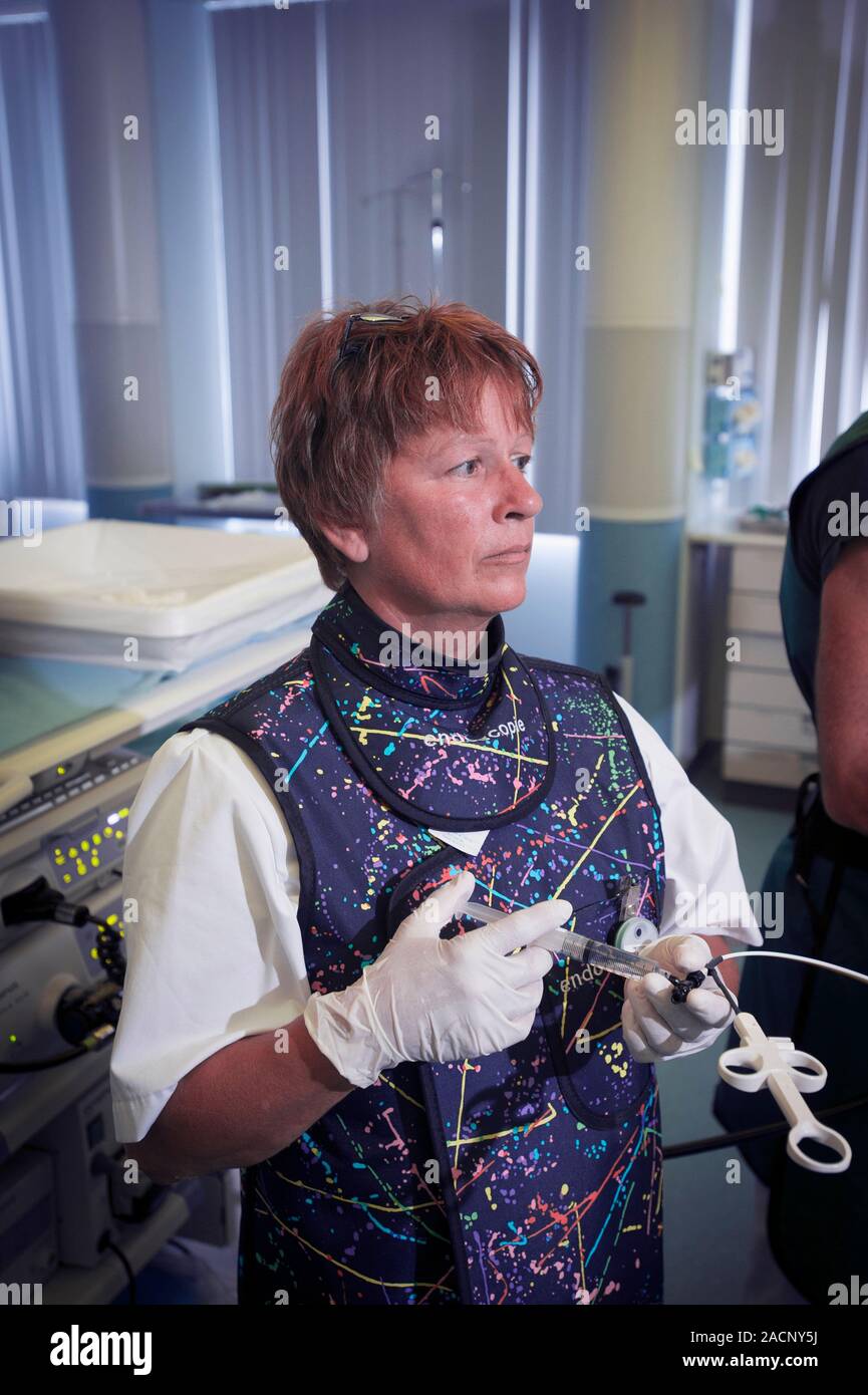 Colonoscopy. Nurse assisting a doctor to perform a colonoscopy on a ...