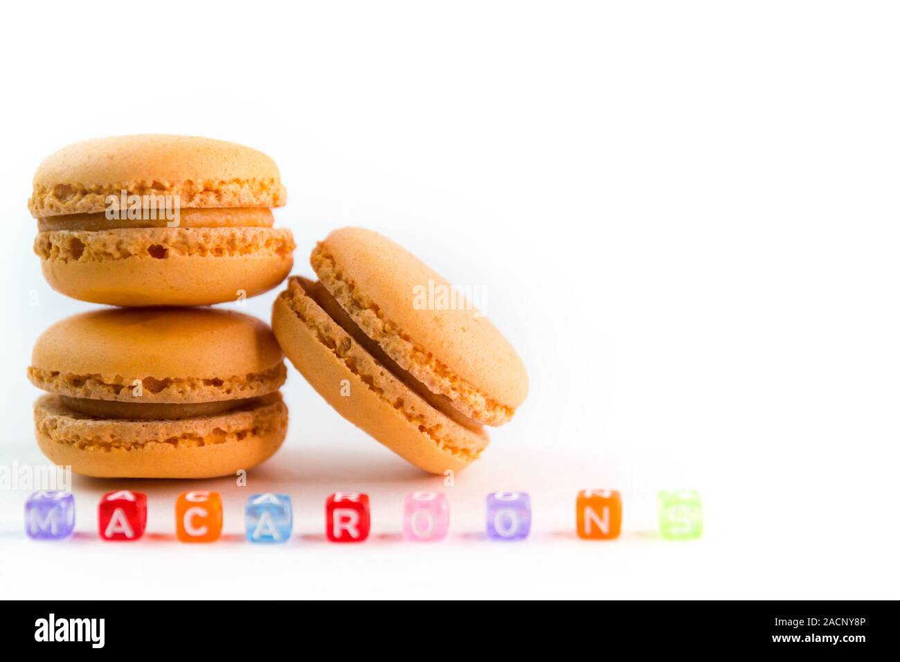 Macaroons with colorful cube letters on white background top, color ...