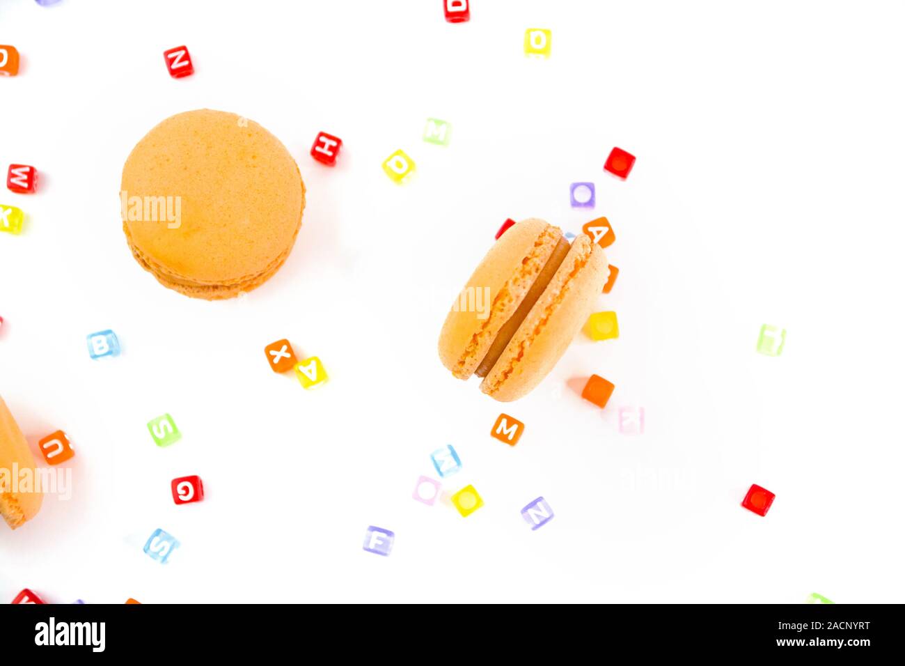 Macaroons with colorful cube letters on white background top, color ...