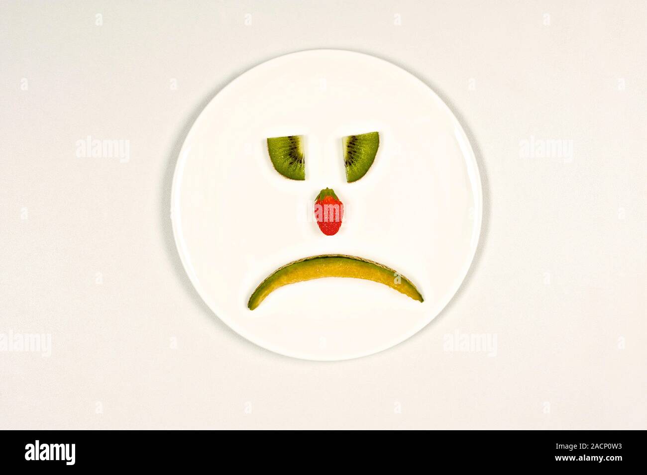 Sad food face. Food items arranged on a plate to represent a sad face ...