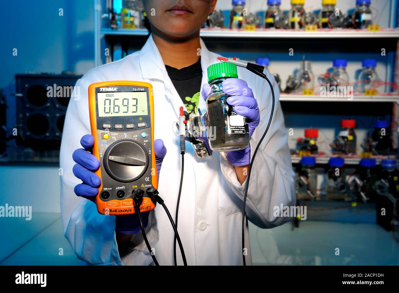 Biofuel battery research. Researcher using a multimeter to show the ...