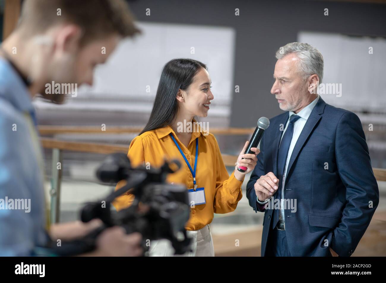 Asian female reporter holding a microphone in her hand Stock Photo - Alamy