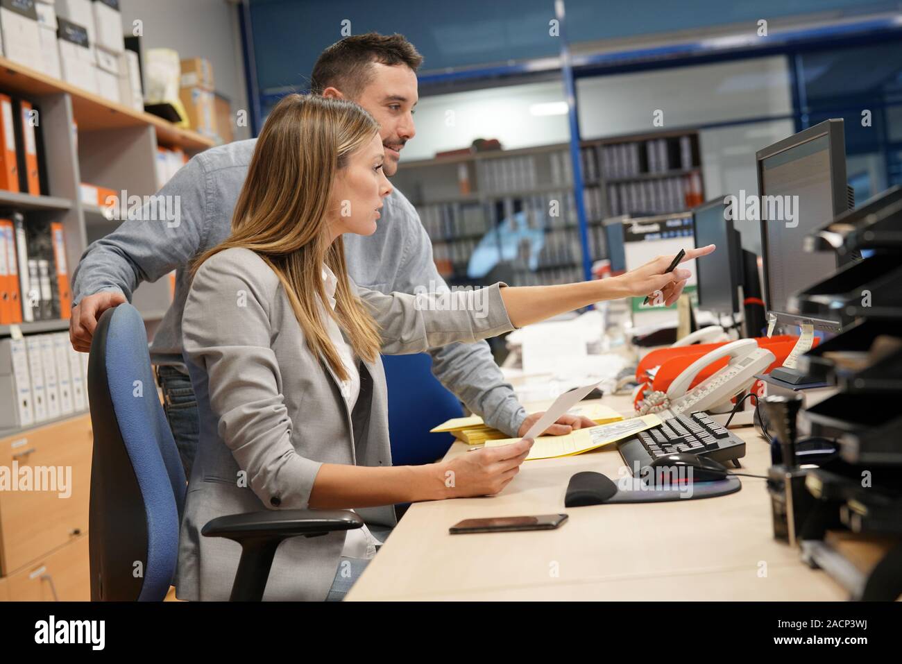 Office manager giving instructions to workmate Stock Photo - Alamy