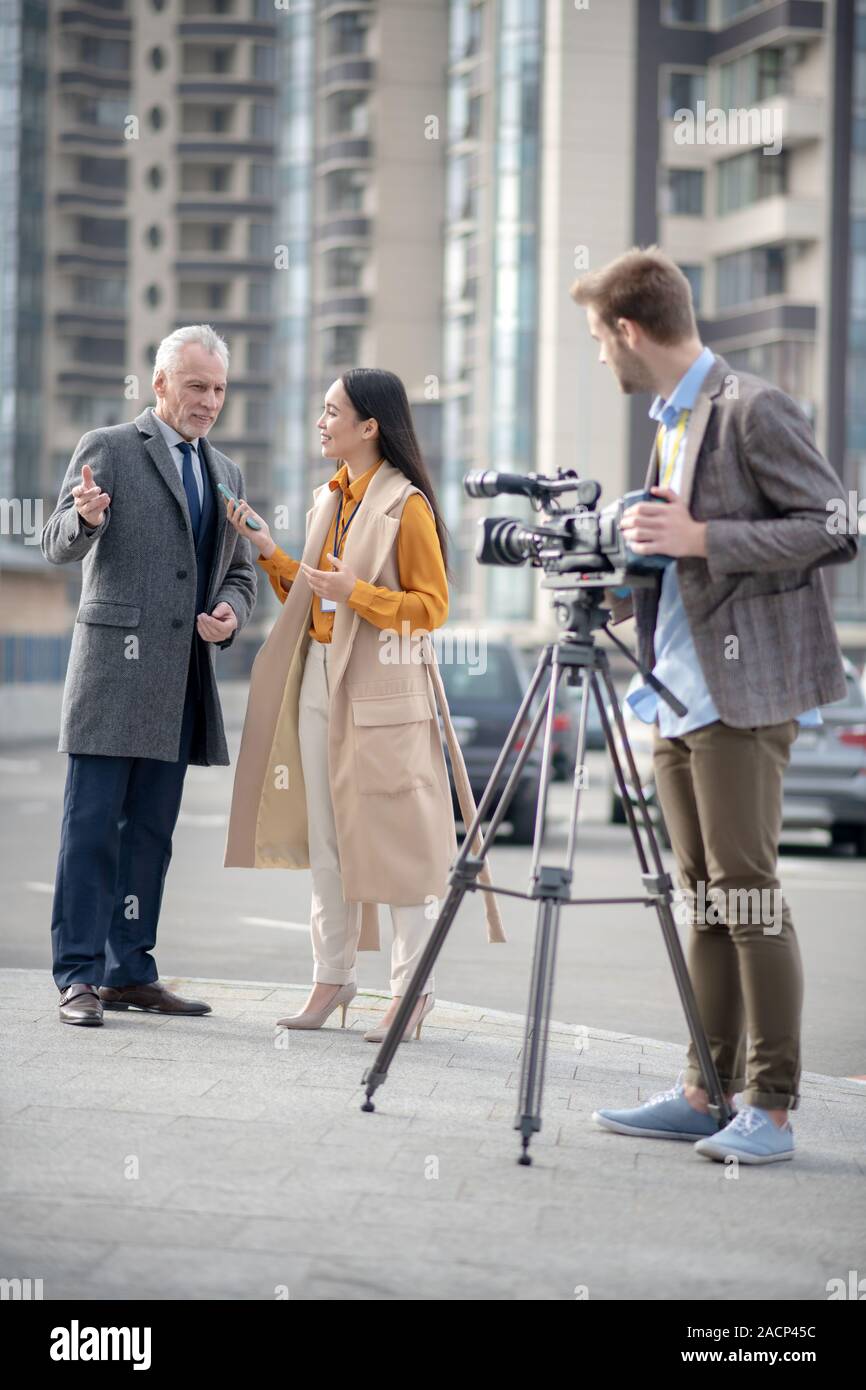 Young cute female reporter talking to a famous businessman Stock Photo ...