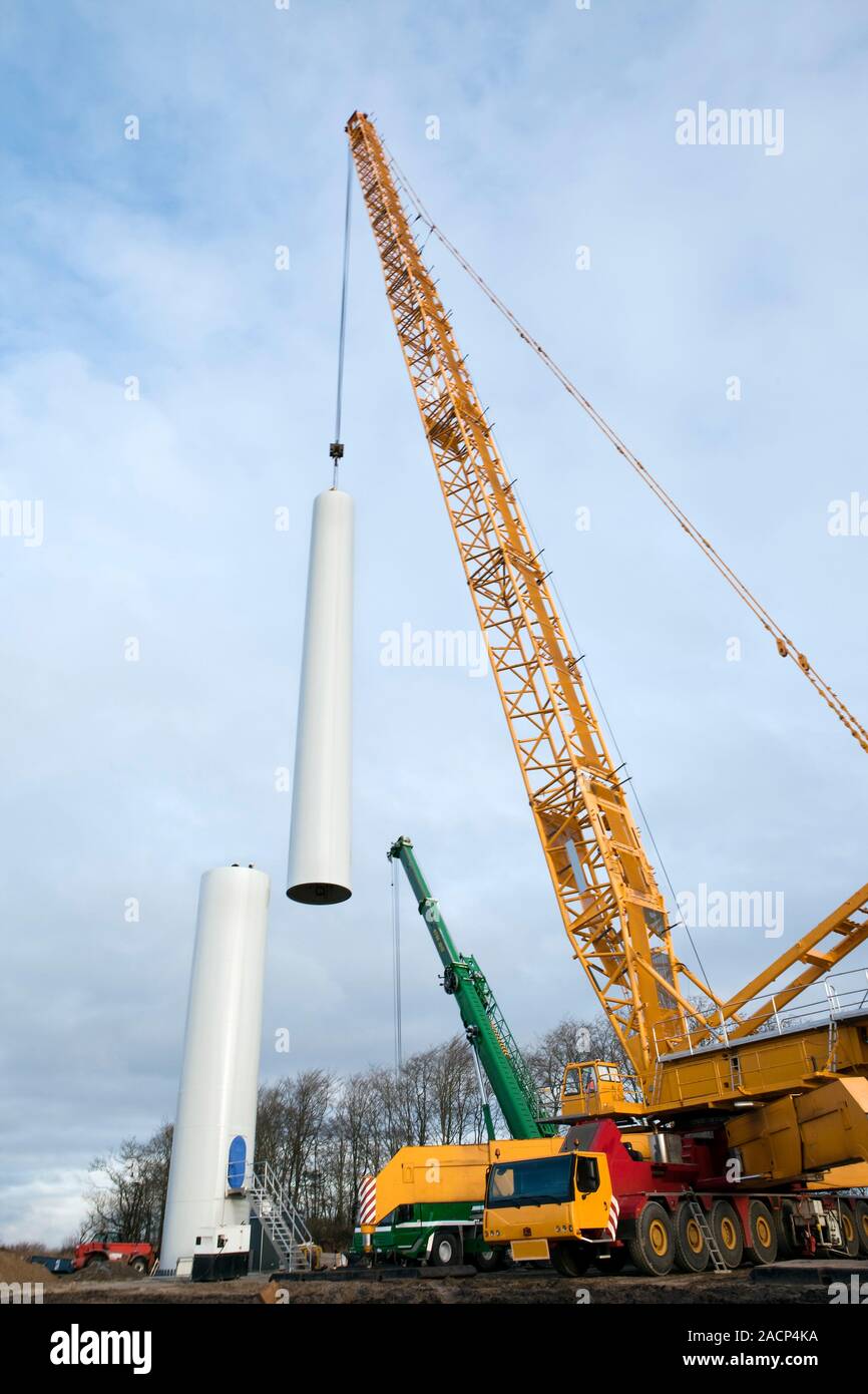 Wind turbine assembly. Industrial workers using a crane to lift wind ...