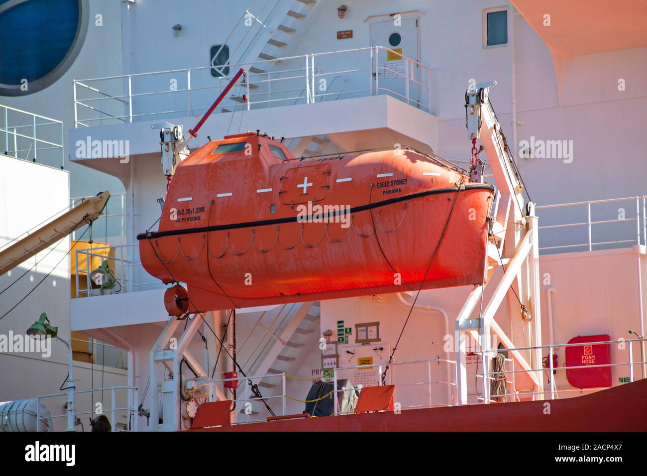 Shipboard lifeboat. Modern enclosed shipboard lifeboat on davits on an ...