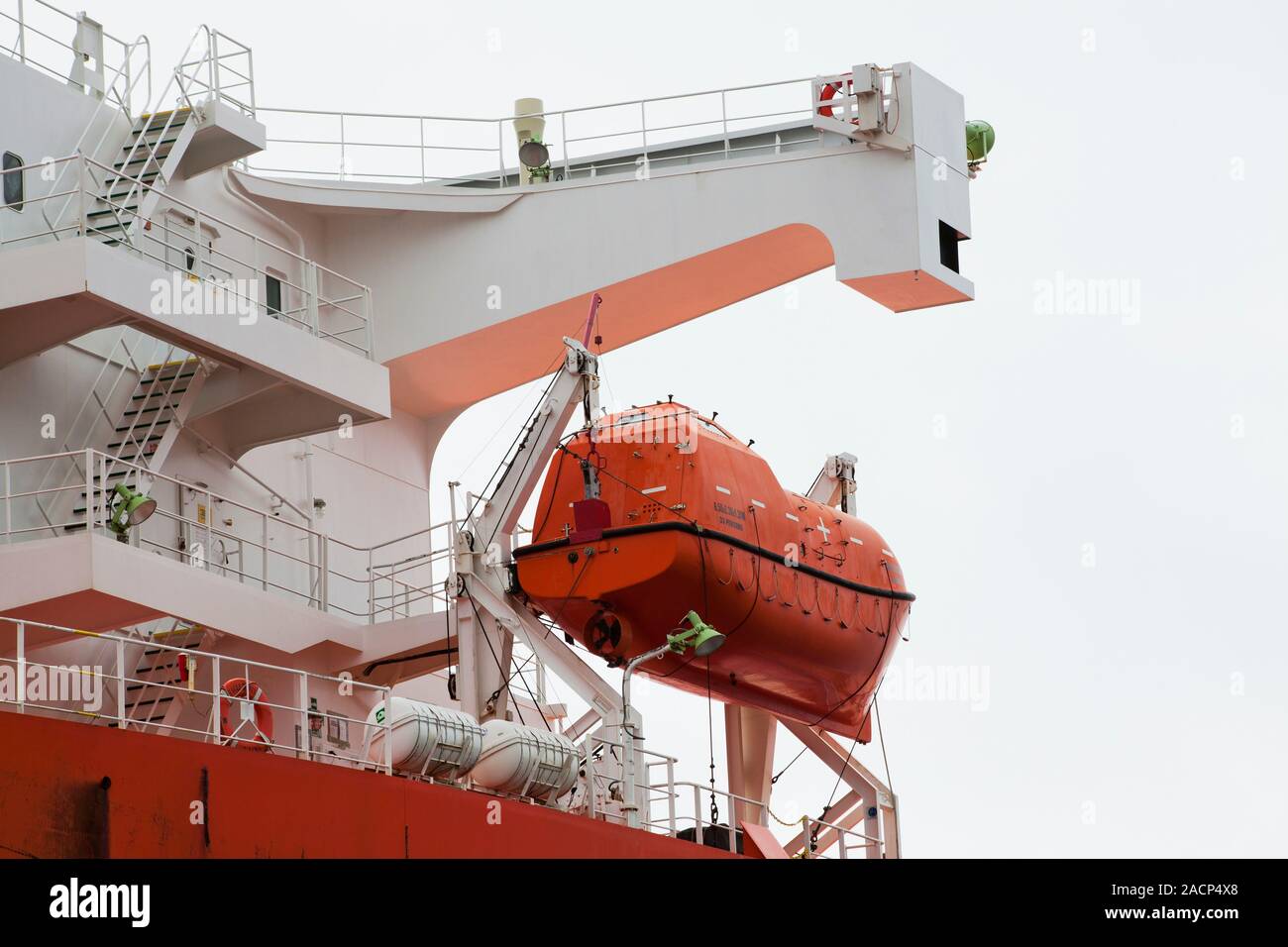 Shipboard lifeboat. Modern enclosed shipboard lifeboat on davits on an ...