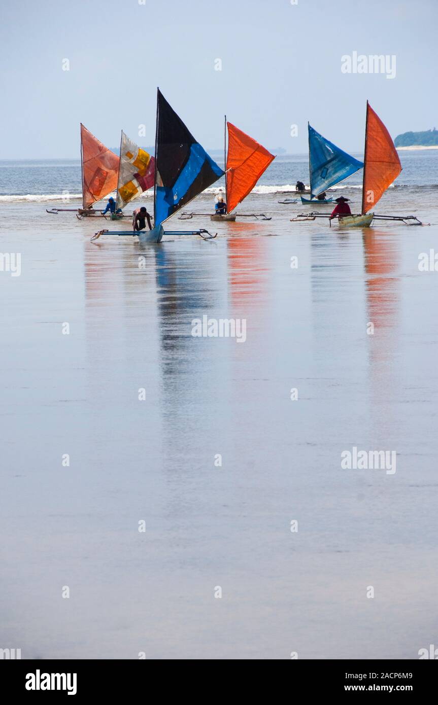 A group of colourful traditional sailing boats along the shore of ...