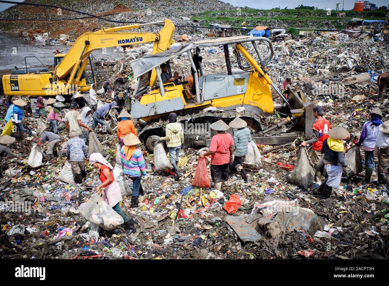 Landfill scavenging. People searching newly dumped landfill rubbish for ...