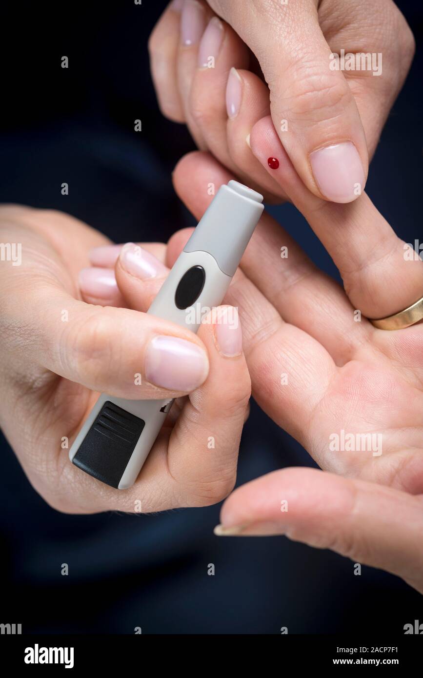 Diabetes clinic, blood sugar test. Hands of a nurse using a lancing ...