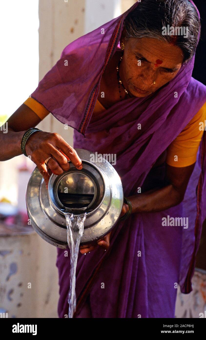 Hindu woman. Woman pouring water from a jug inside a Hindu temple ...