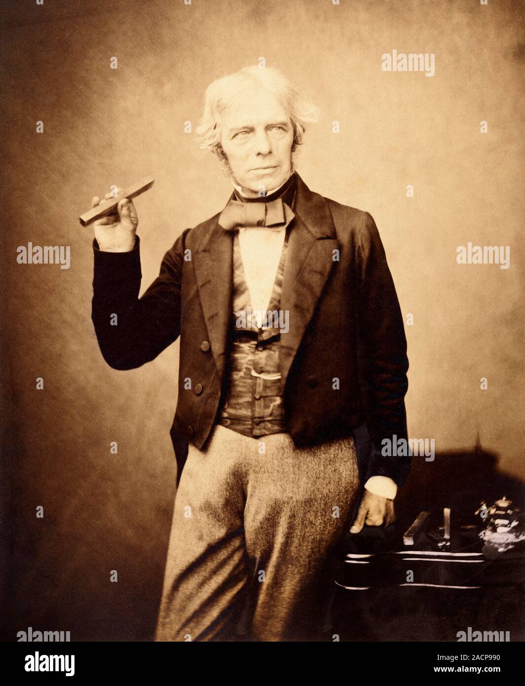 Michael Faraday (1791-1867), British chemist and physicist, holding a ...