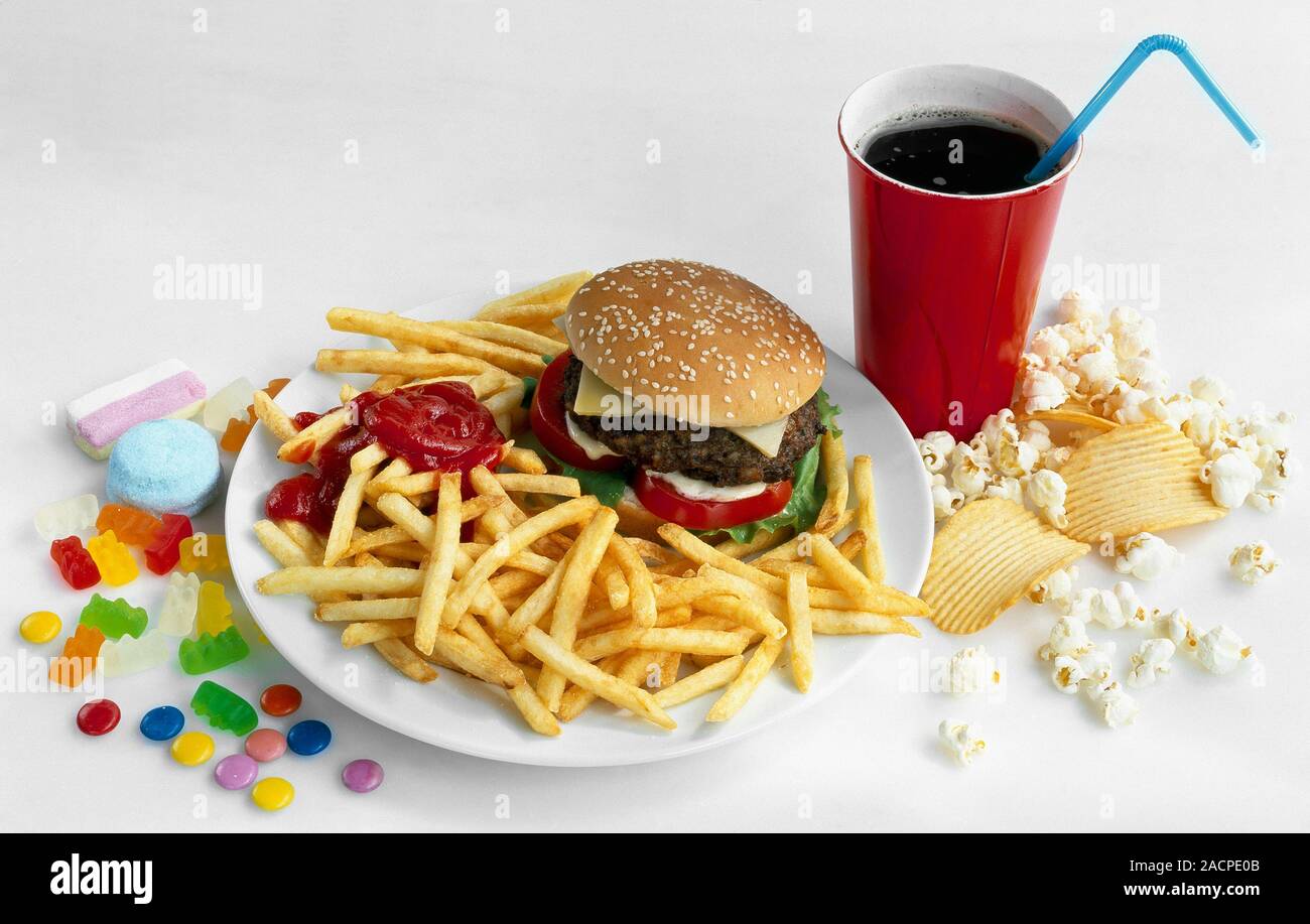 Junk food. Cheeseburger in a sesame seed bun with salad vegetables, on ...