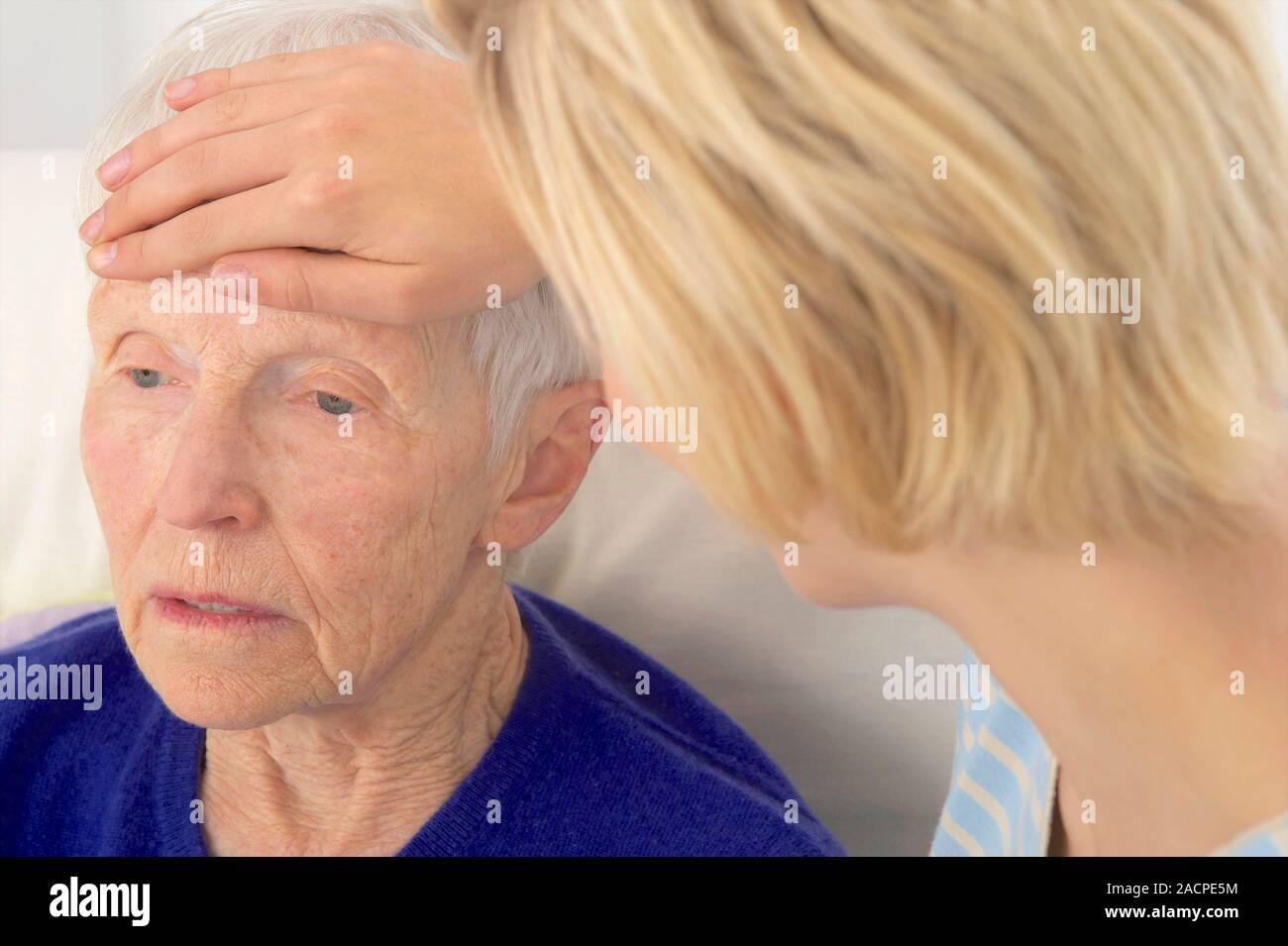 Elderly woman with a fever. Young woman caring for an 82-year-old woman ...