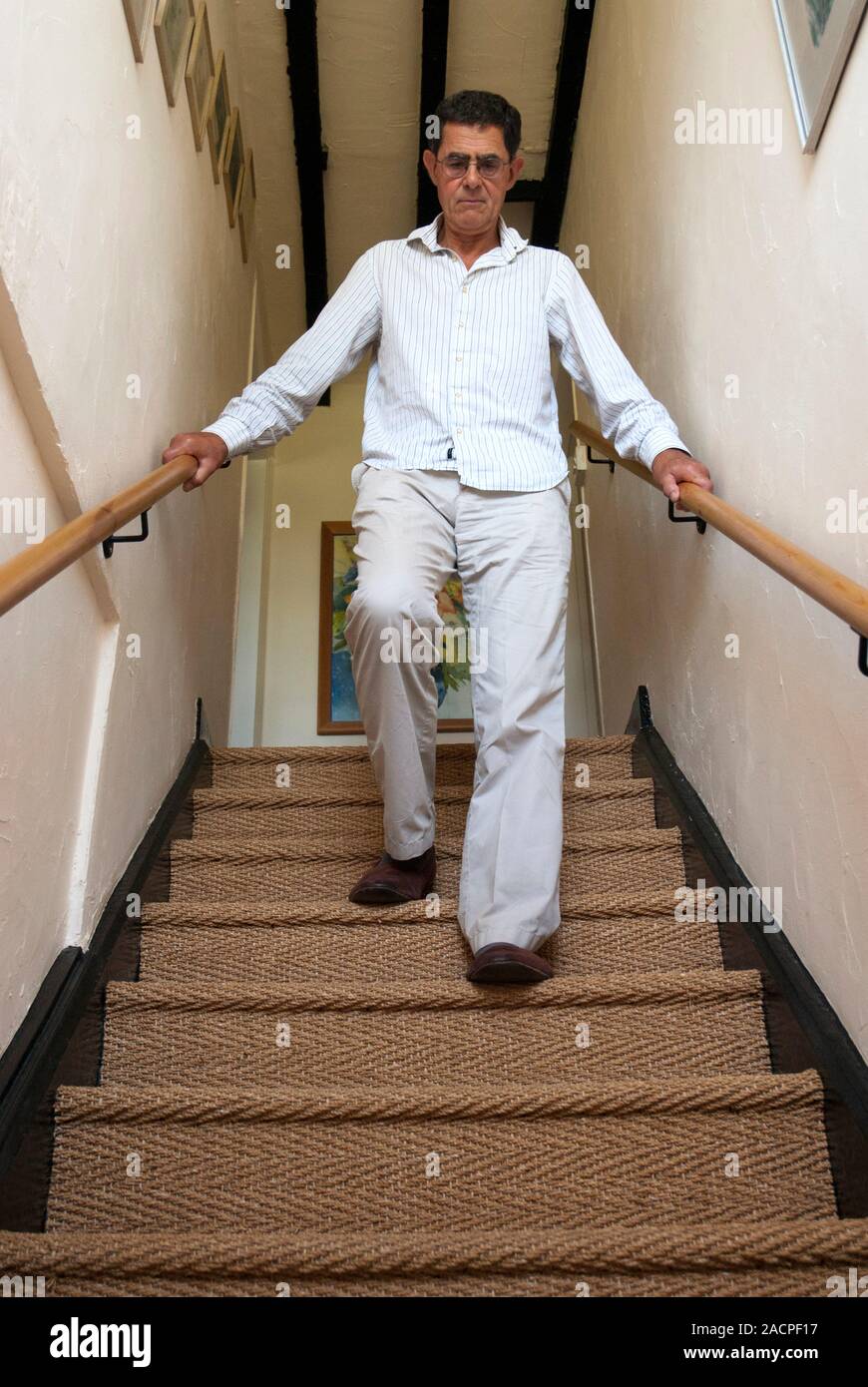 Walking down stairs. Middle-aged man walking down a flight of stairs ...