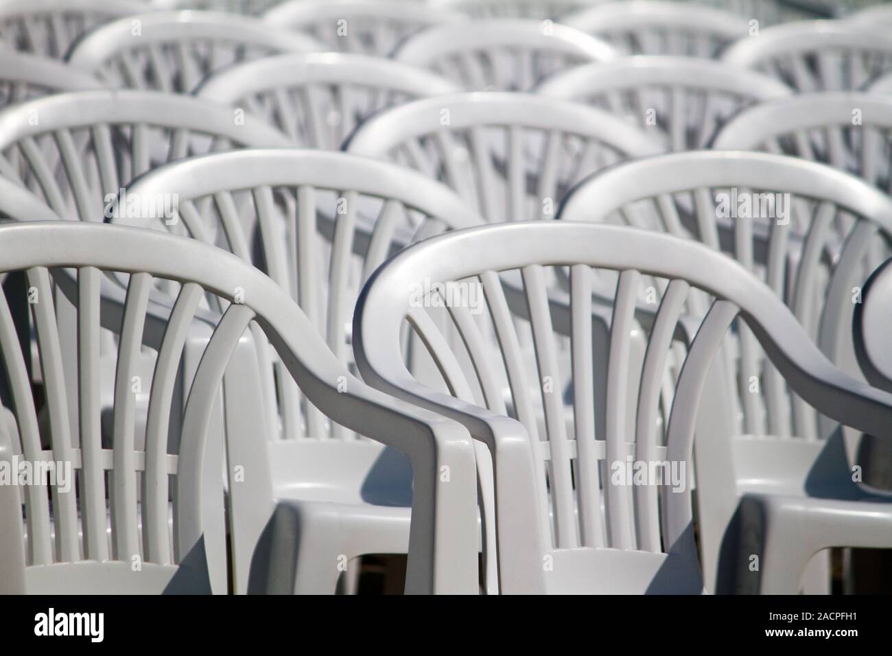 aligned white plastic chairs Stock Photo - Alamy