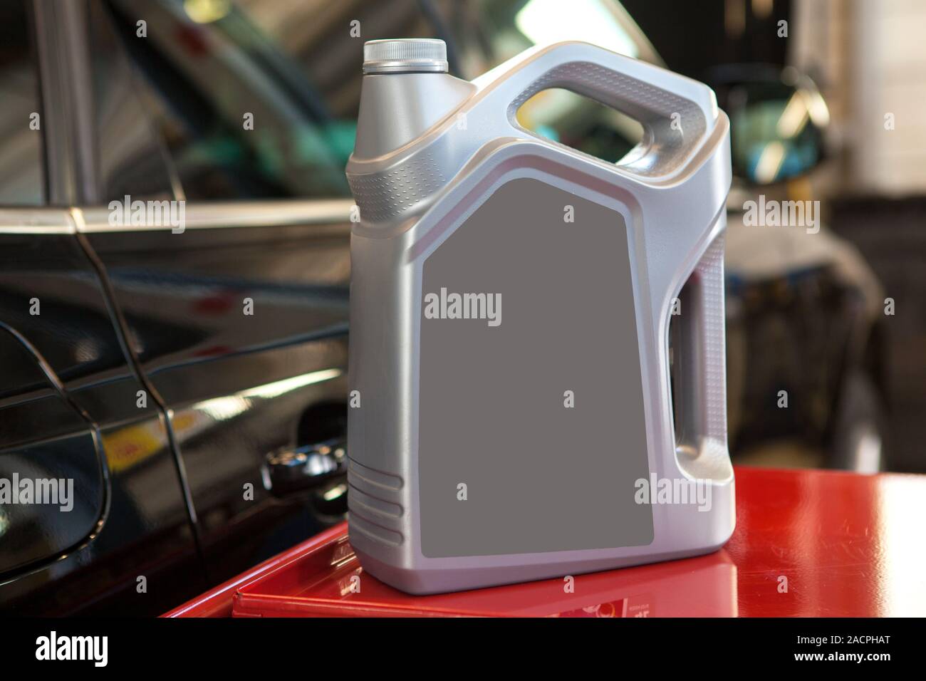 Engine oil canister with black label in a colorful blurred background ...