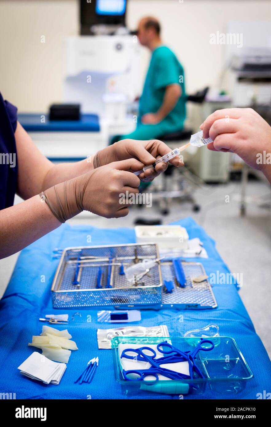 Laser eye surgery equipment. Syringe and needle being prepared for use ...