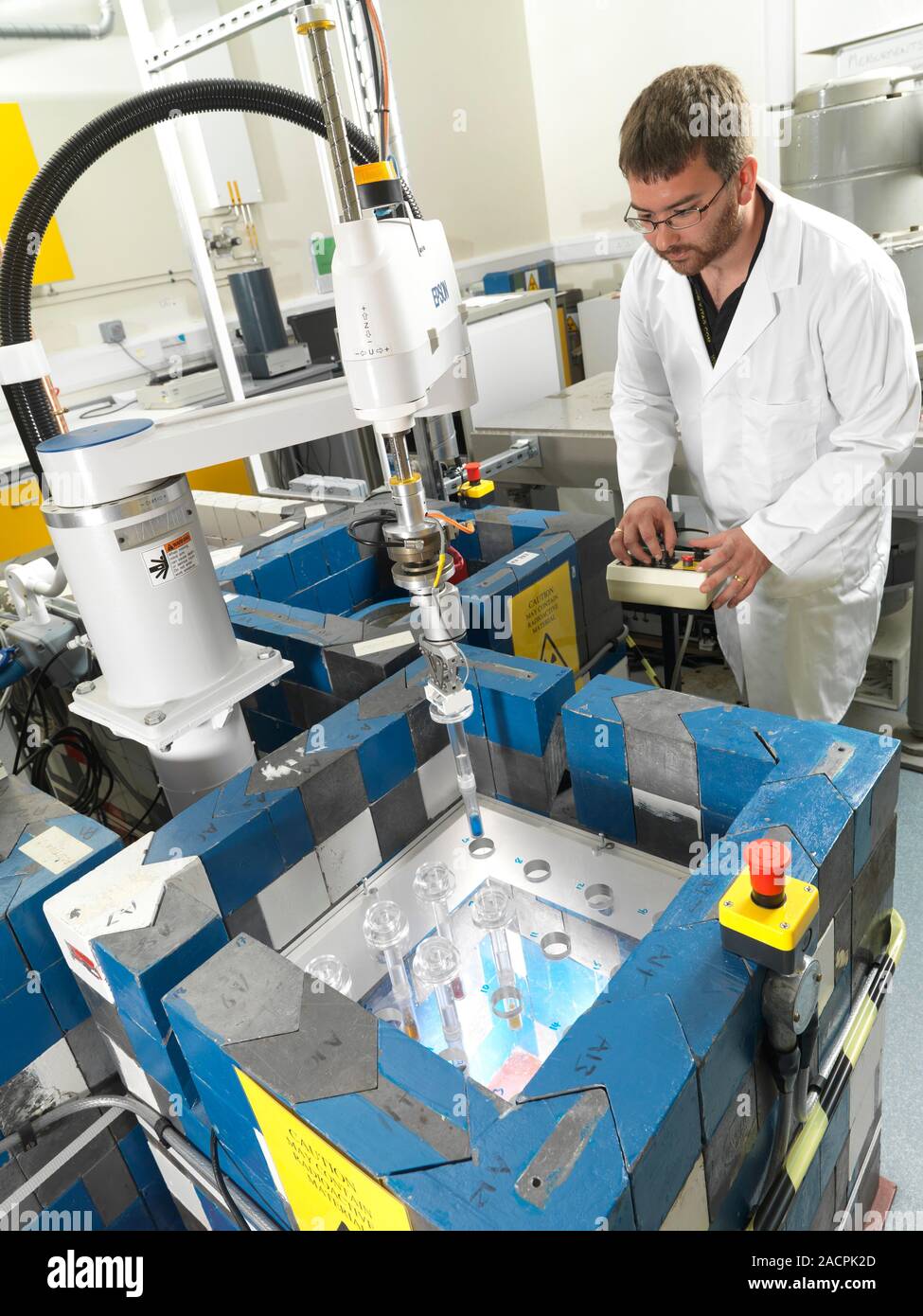 Automatic sample changer. Researcher operating a robotic arm to remove ...