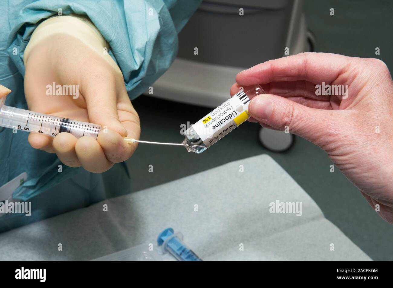 Lidocaine local anaesthetic. Doctors preparing a syringe of lidocaine ...