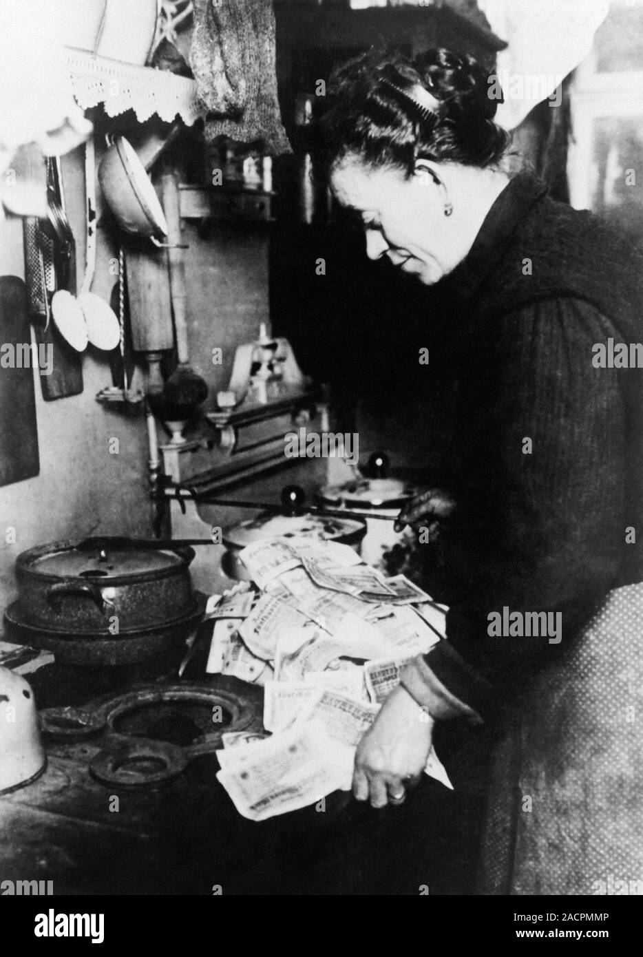 Burning money. Woman burning German currency (German Papiermark) during ...