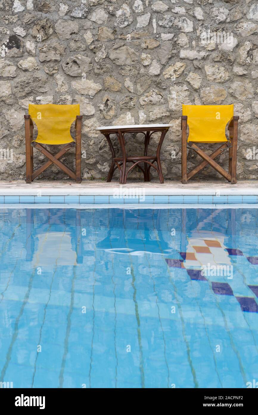 Swimming pool with table and chairs Stock Photo - Alamy
