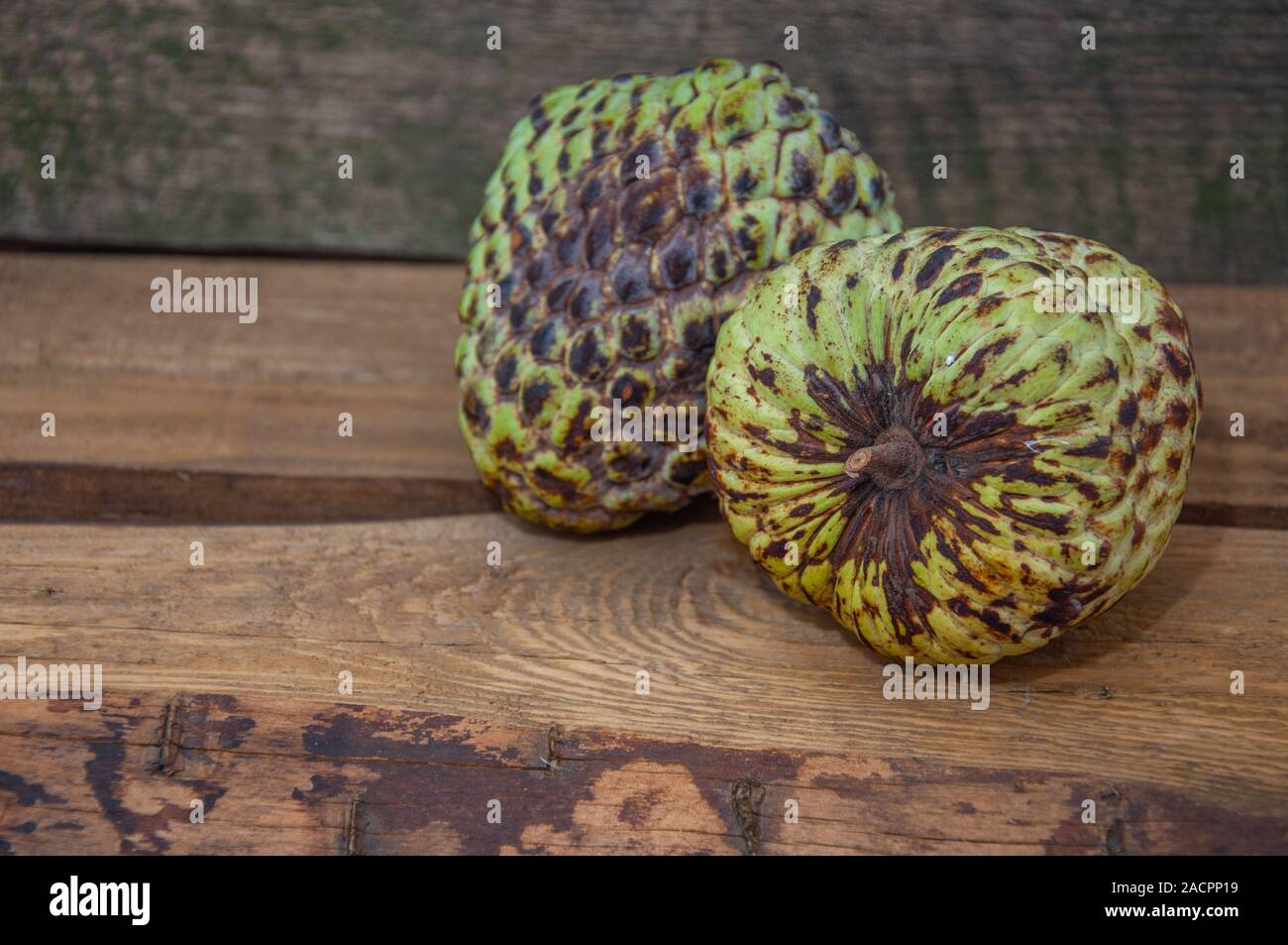Cherimoya fruit on wooden table background. Two cherimoyas. Close up ...