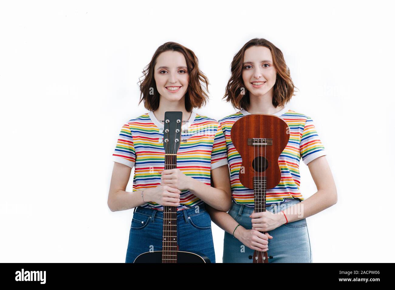 Two twin sisters with musical instruments in their hands Stock Photo ...
