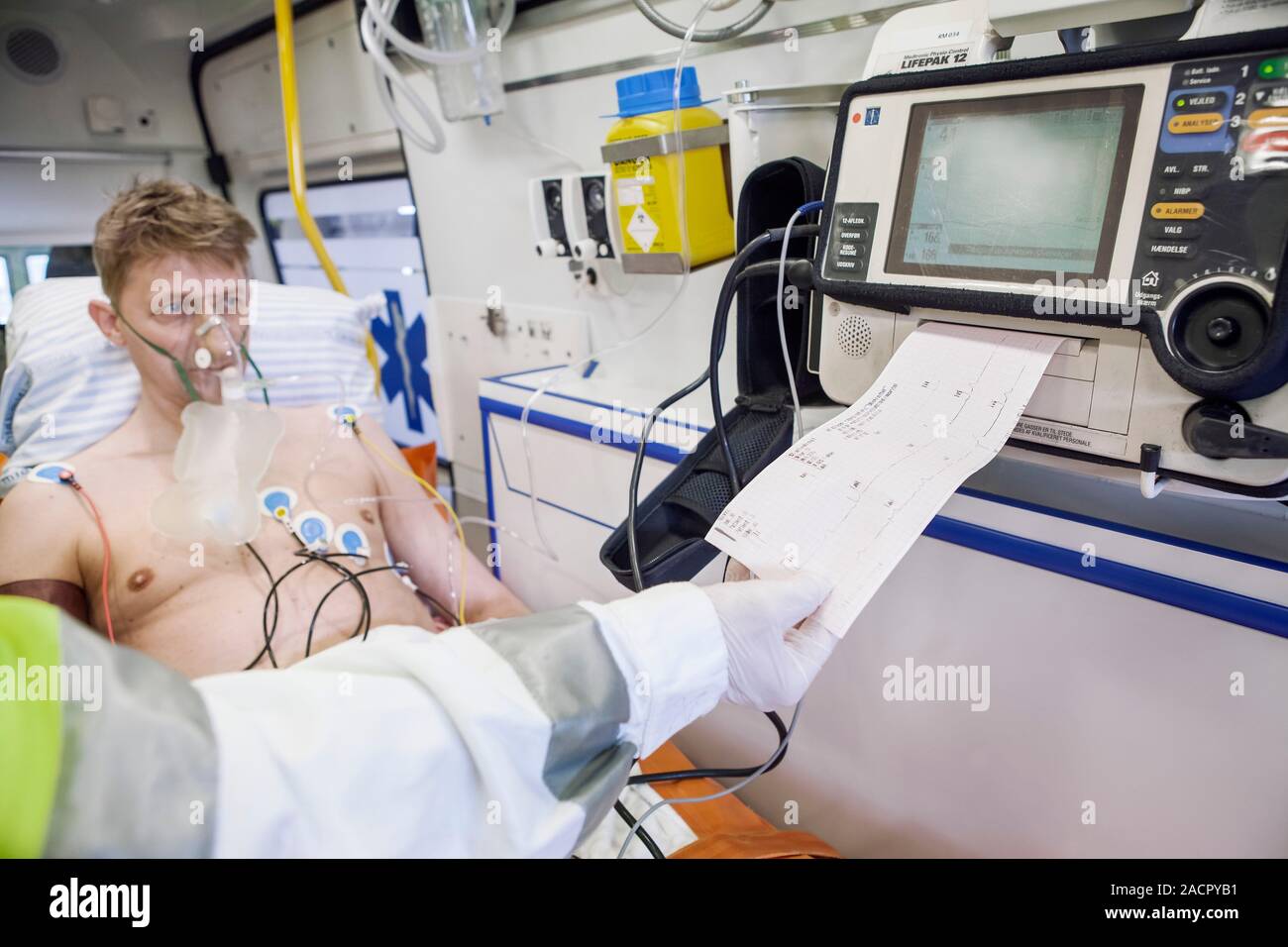Cardiac patient in an ambulance. Paramedic performing an ...