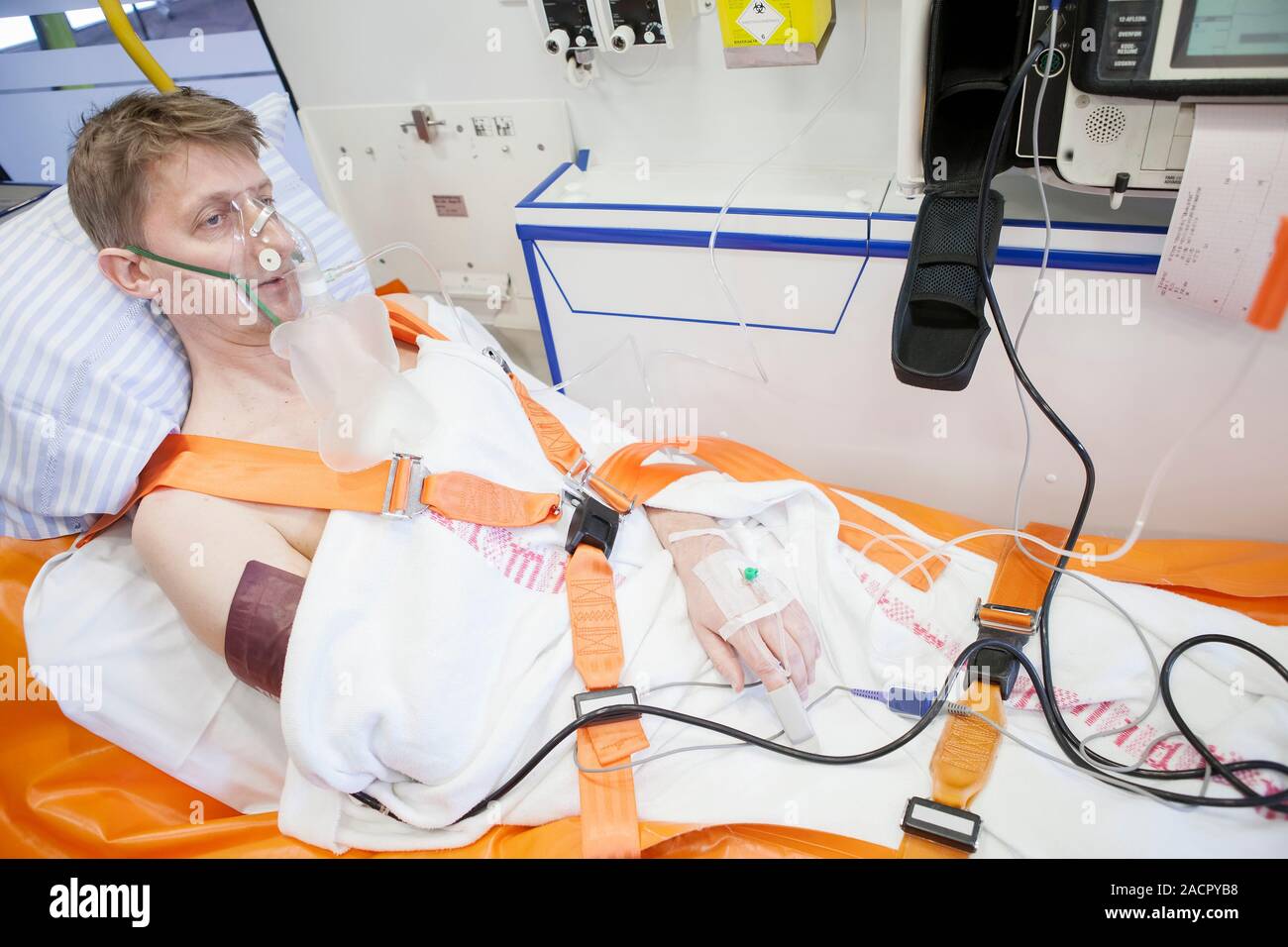 Cardiac patient in an ambulance. 50-year-old cardiac patient connected ...