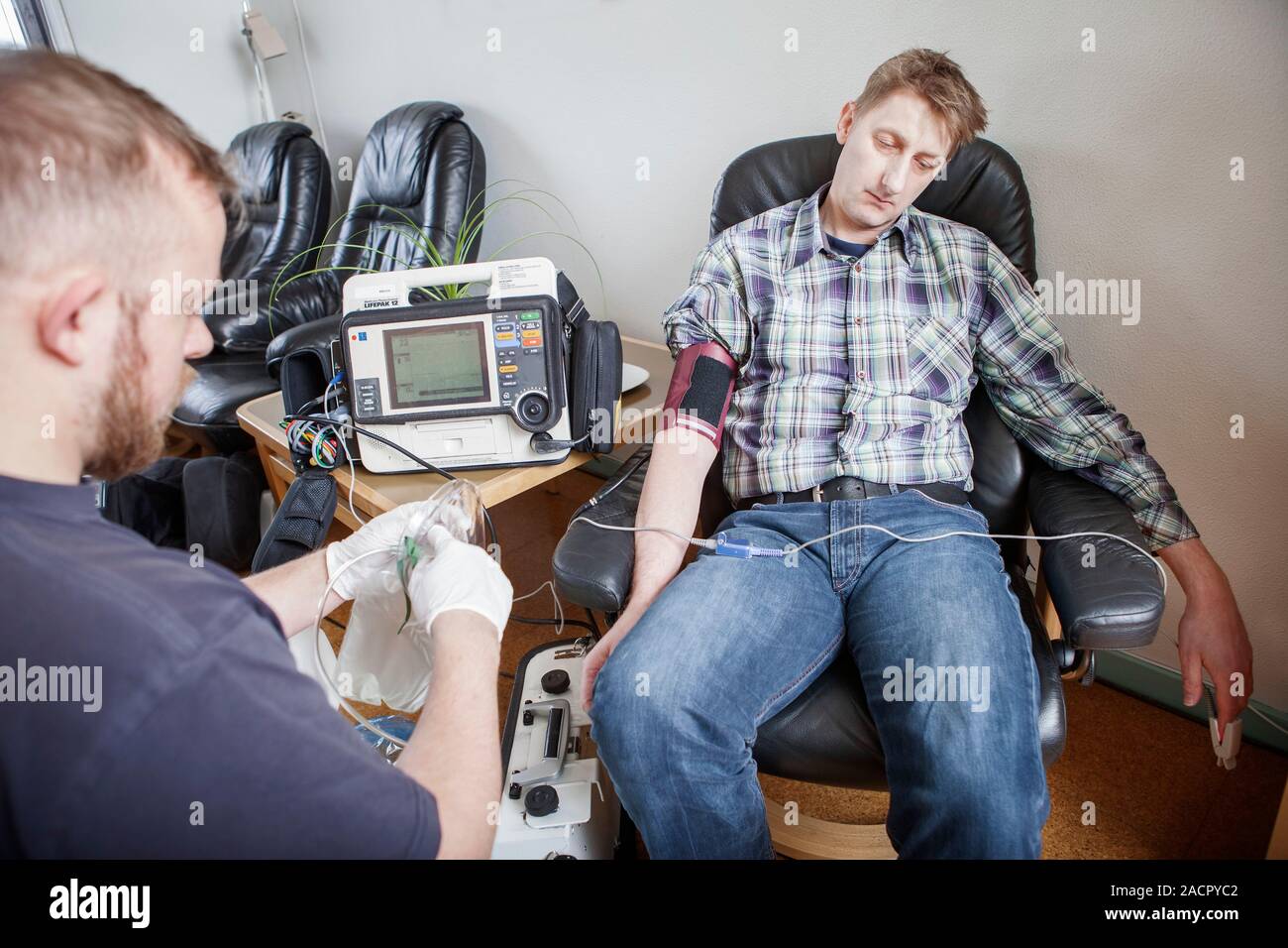 Stroke patient. Paramedic attending to a 50-year-old stroke patient. A ...