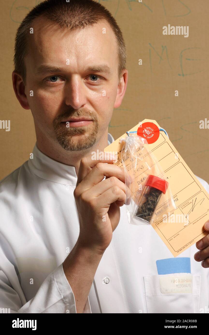 Forensic soil sample. Policeman holding a sample of soil taken from a ...