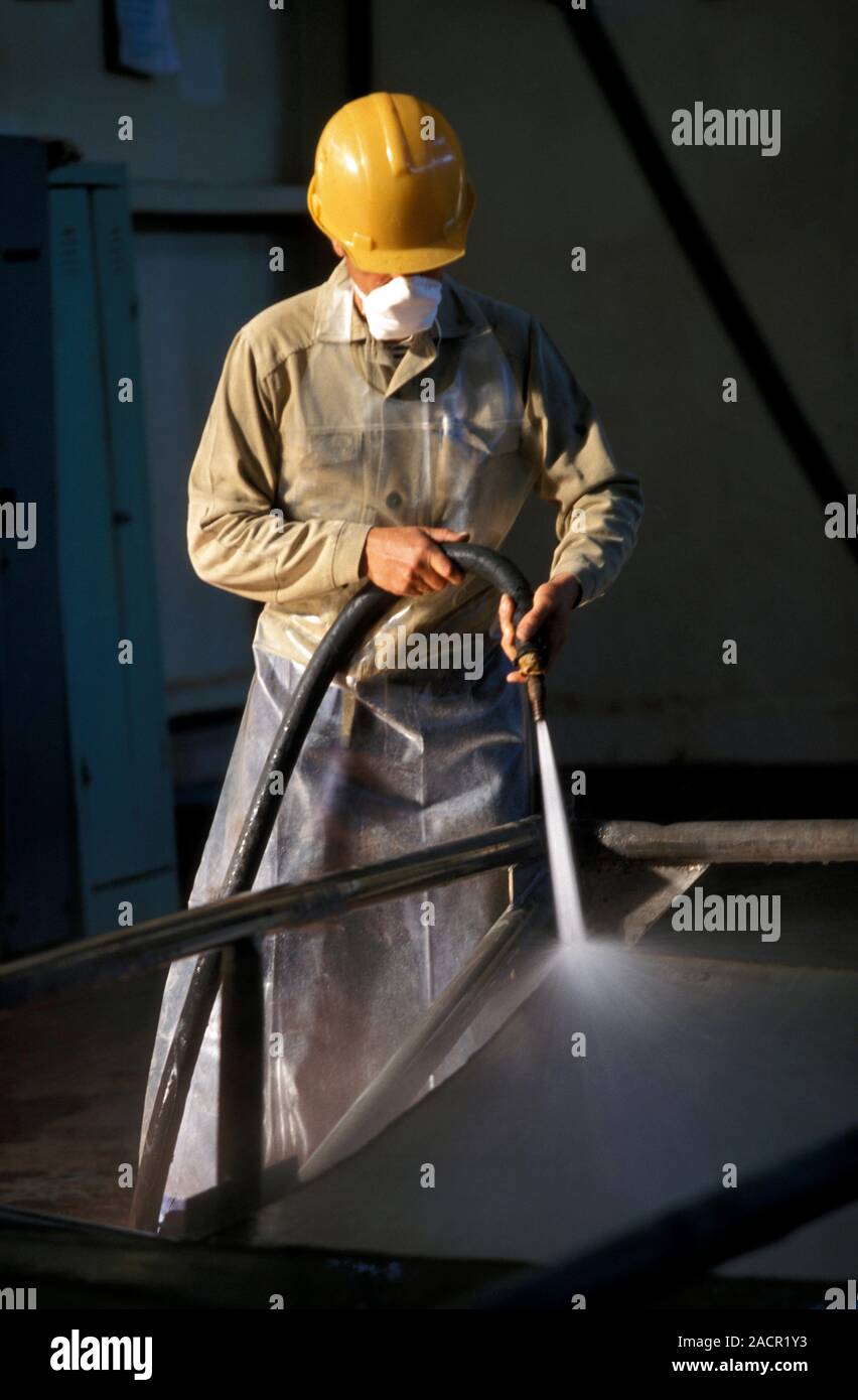 Chernobyl decontamination plant. Worker using a jet of steam as part of ...