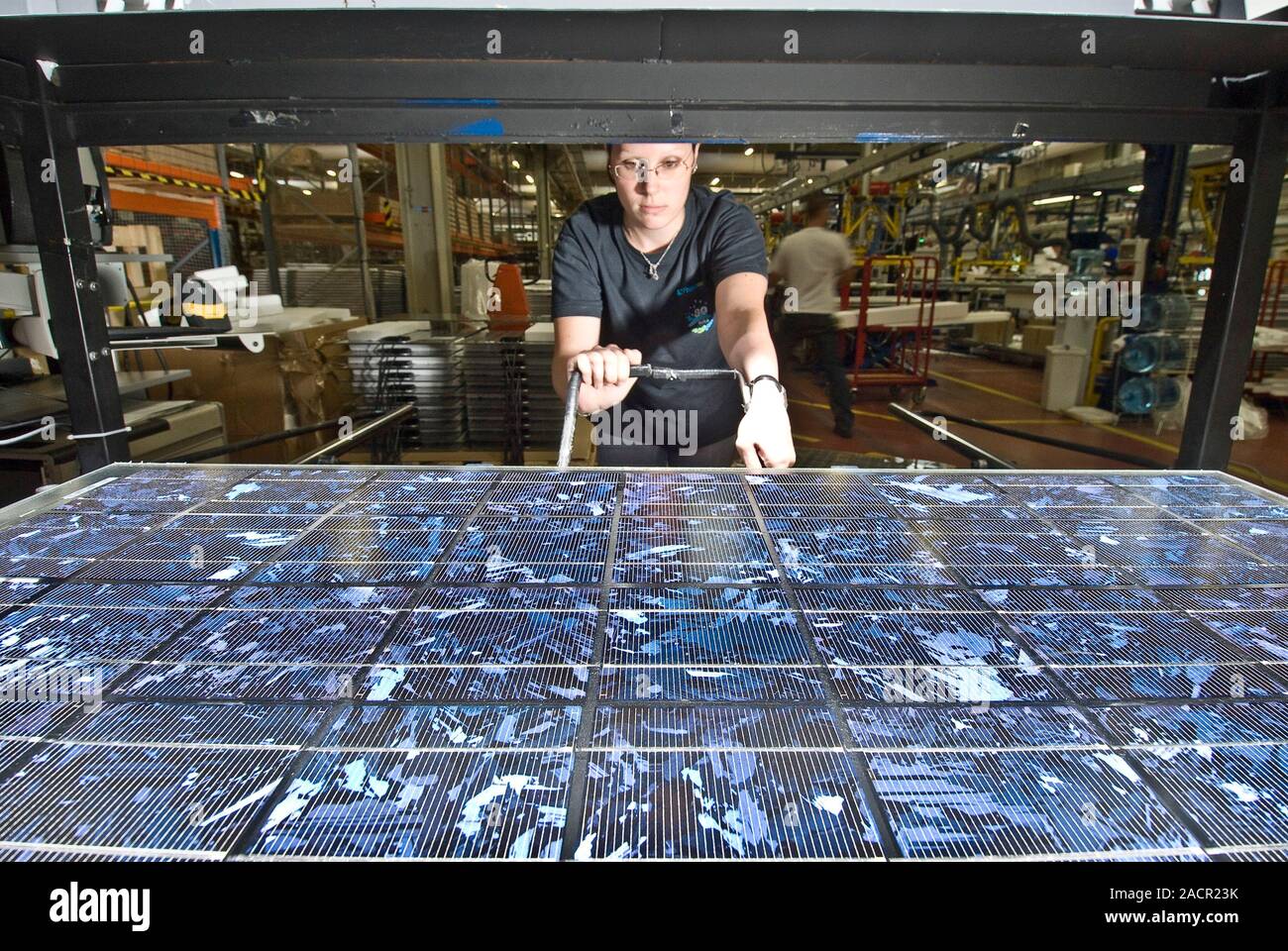 Manufacturing solar panels. Factory worker loading a newly-made solar ...