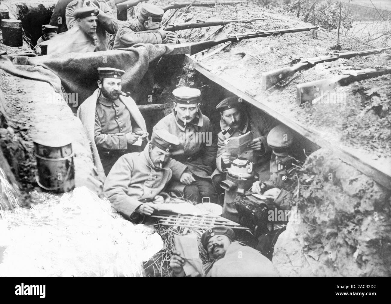 German trenches. German soldiers smoking and reading in a trench during ...