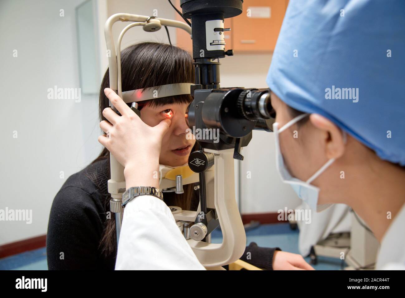 Eye test. Ophthalmologist using a slit lamp ophthalmoscope during an ...