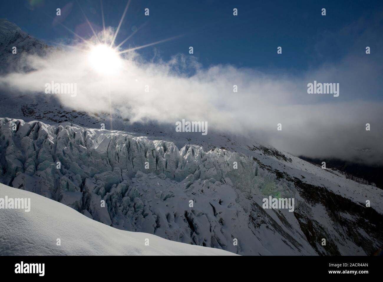 Serac ice blocks. Sunlit clouds over ice blocks on the Argentiere ...